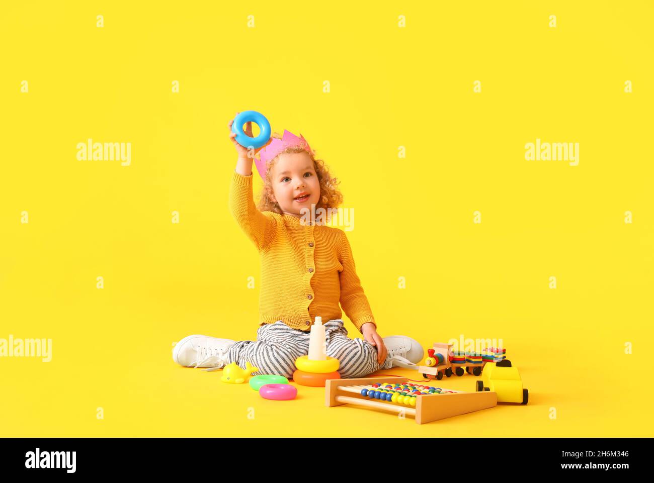 Cute baby girl with toys on color background Stock Photo - Alamy