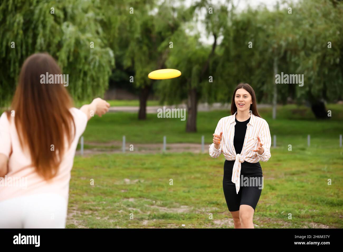 Beautiful young women playing frisbee outdoors Stock Photo - Alamy