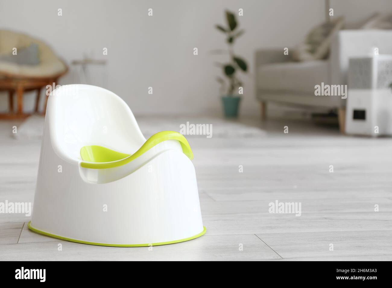 White potty on grey floor in room Stock Photo - Alamy