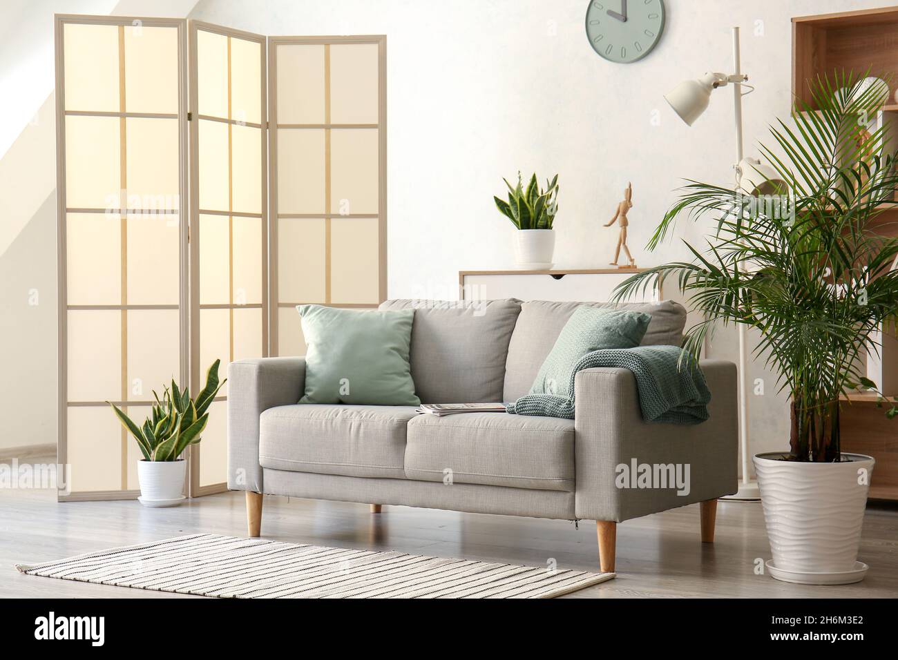 Stylish folding screen near sofa in living room interior Stock Photo ...