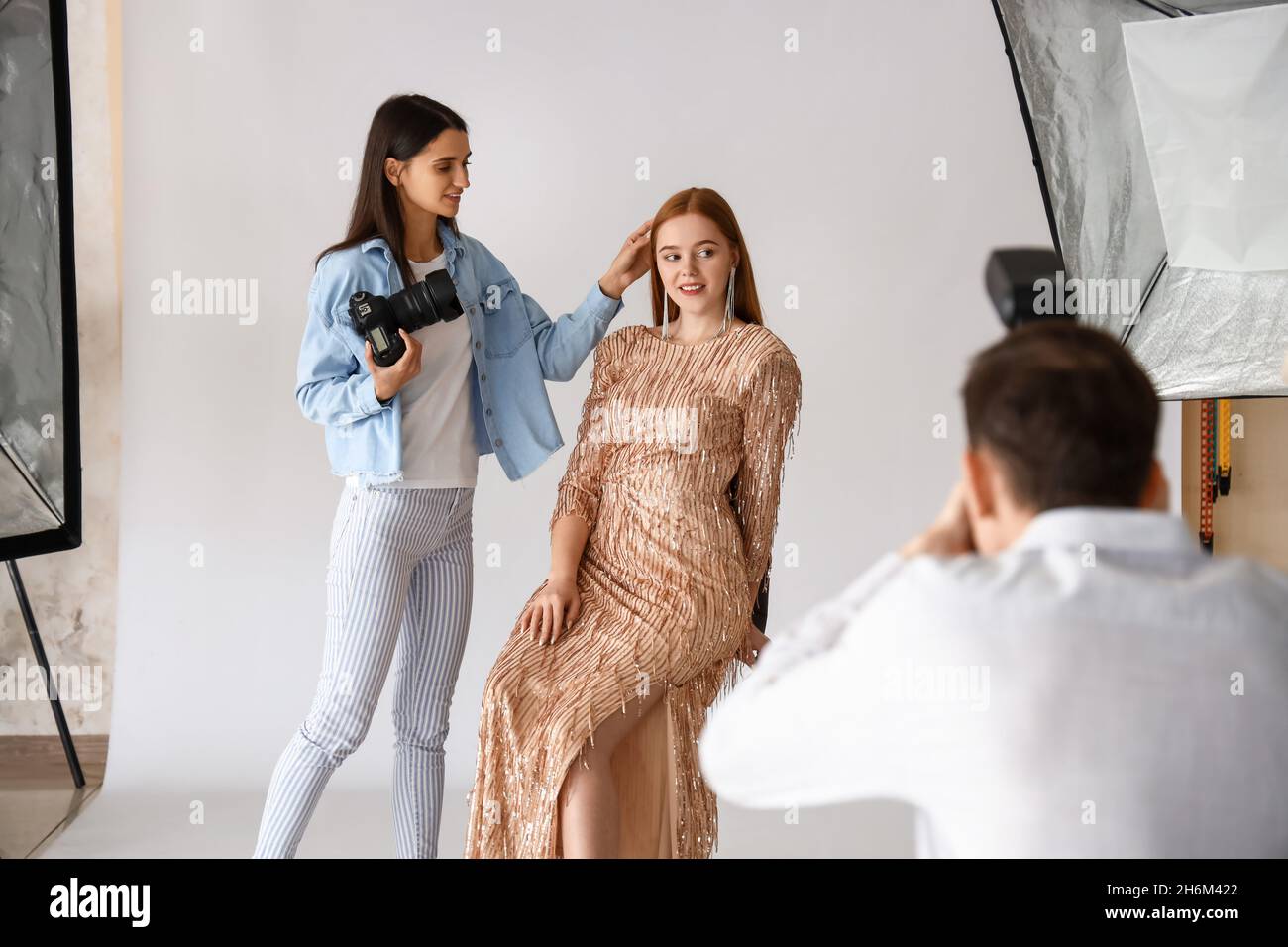 Young photographer taking picture of model in studio Stock Photo - Alamy