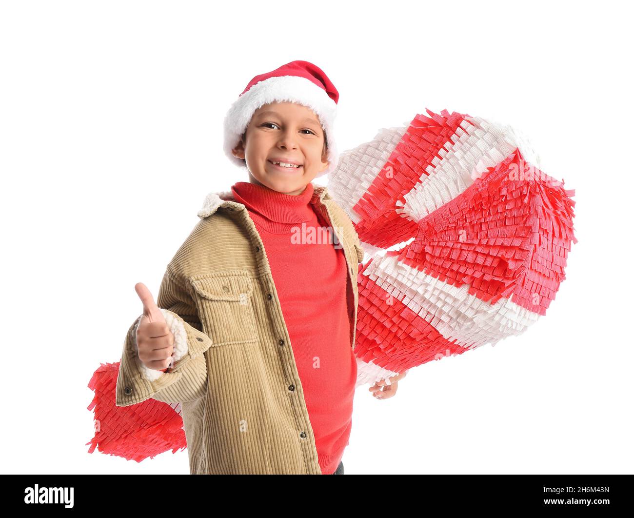 Cute little boy with candy cane pinata showing thumb-up on white ...