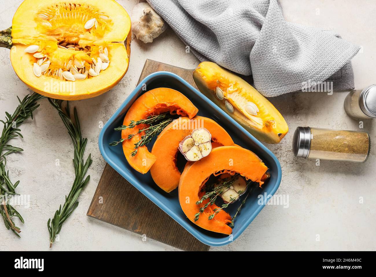 Baking dish with fresh pumpkin pieces on light background Stock Photo ...