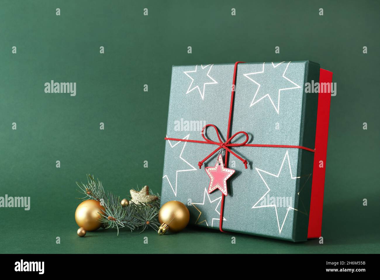 Gift box with card and Christmas decor on green background Stock Photo ...