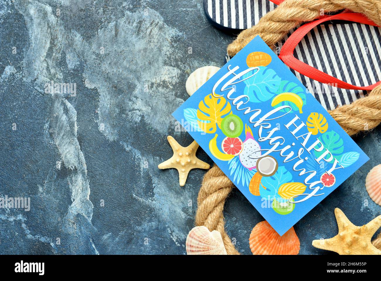 Flip flops, rope, seashells and paper card with text HAPPY THANKSGIVING ...