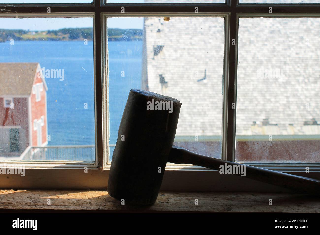 Close-up of an antique wooden mallet hammer on a window sill ...