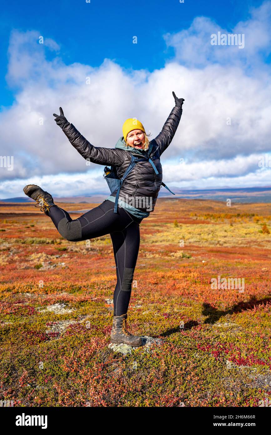 Female Expressing happiness by jumping on Intense Autumn Background ...
