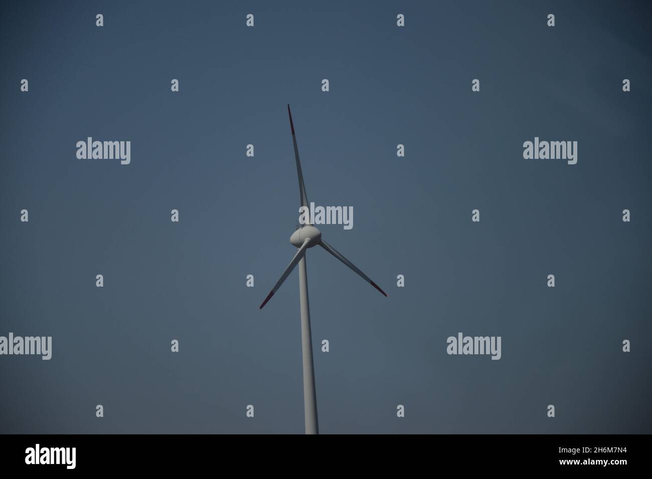 Low angle shot of a white wind energy fan not turned on with a clear ...