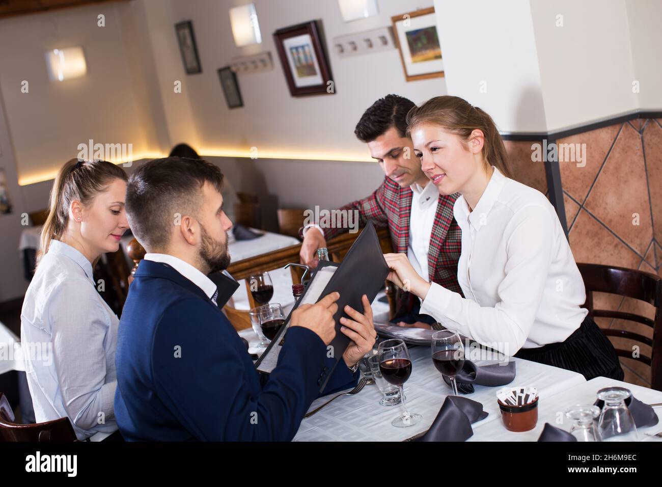 Friends choosing meal from menu Stock Photo - Alamy