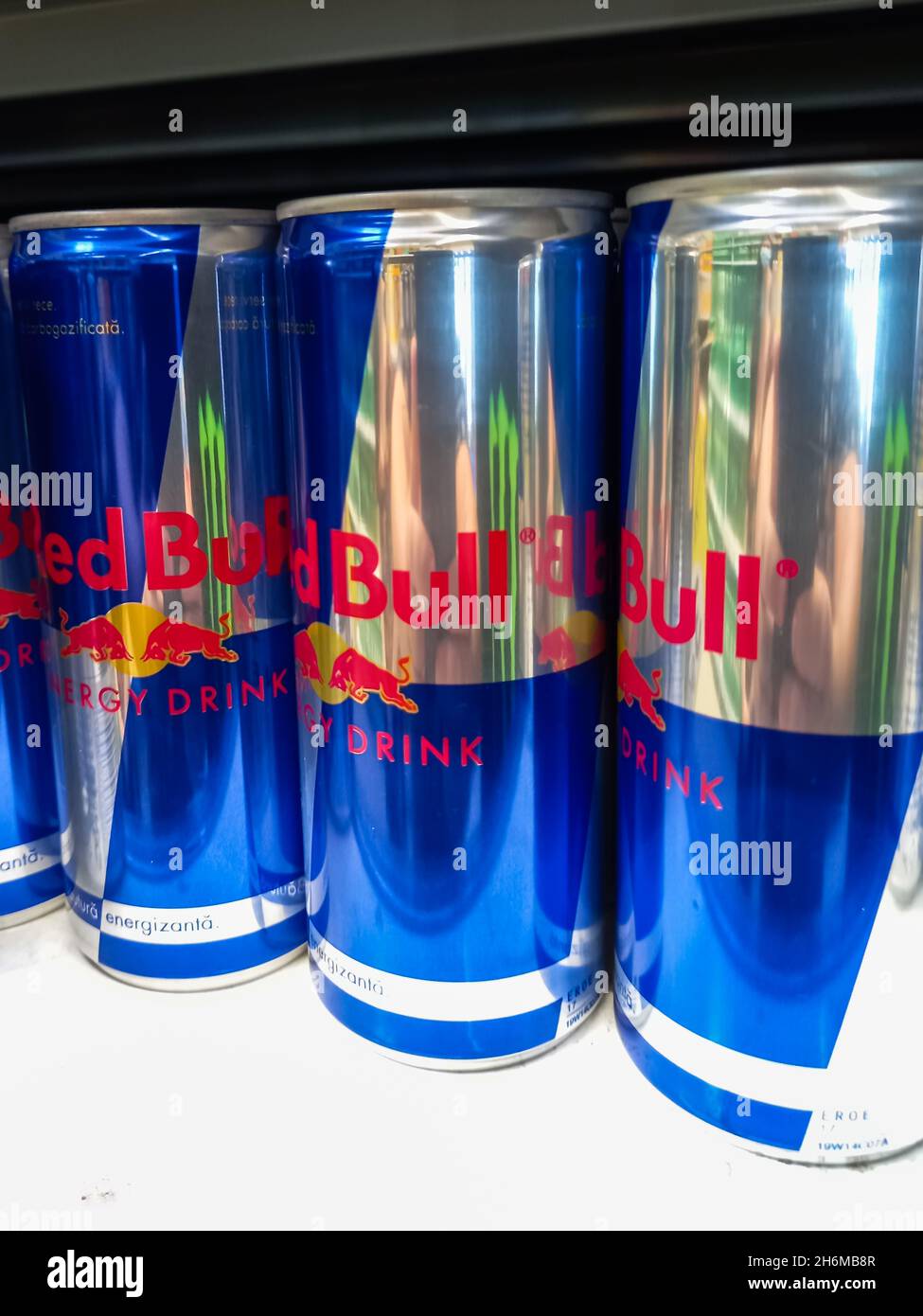 Blue cans of Red Bull energy drink of shelf in supermarket ...