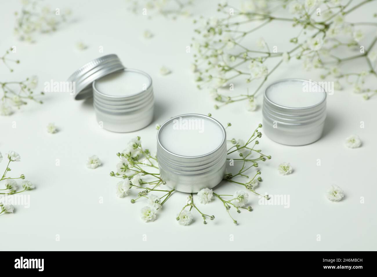 Eco lip balm and flowers on white background Stock Photo - Alamy