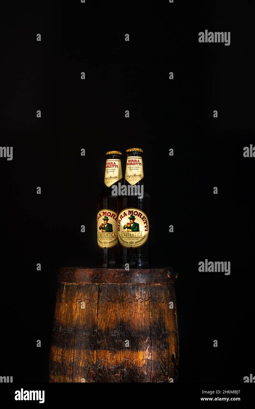 Bottle of Birra Moretti beer on wooden barrel with dark background ...