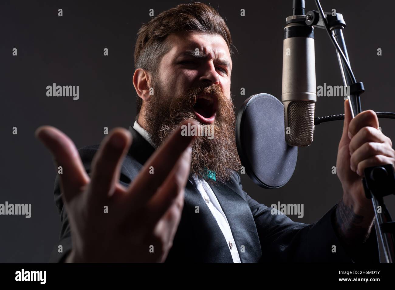 Classic singer in suit. Man singing with music microphone Stock Photo ...