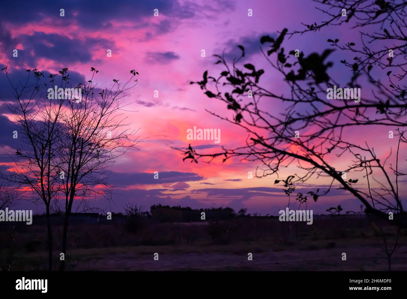 Evening landscape. Beautiful dark sky with colored backlit clouds over ...