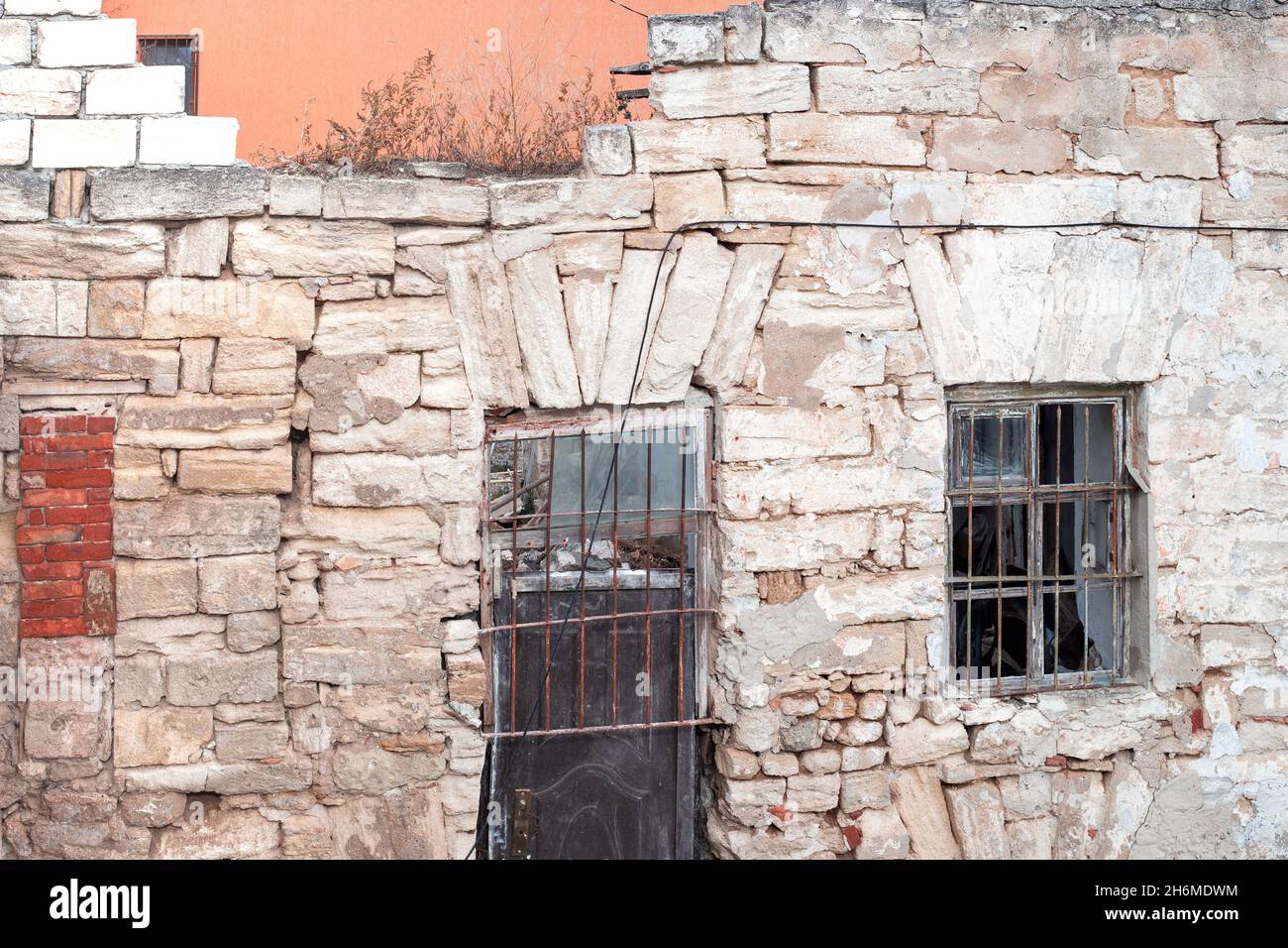 Destroyed stone wall of an old house with a door and a window Stock ...