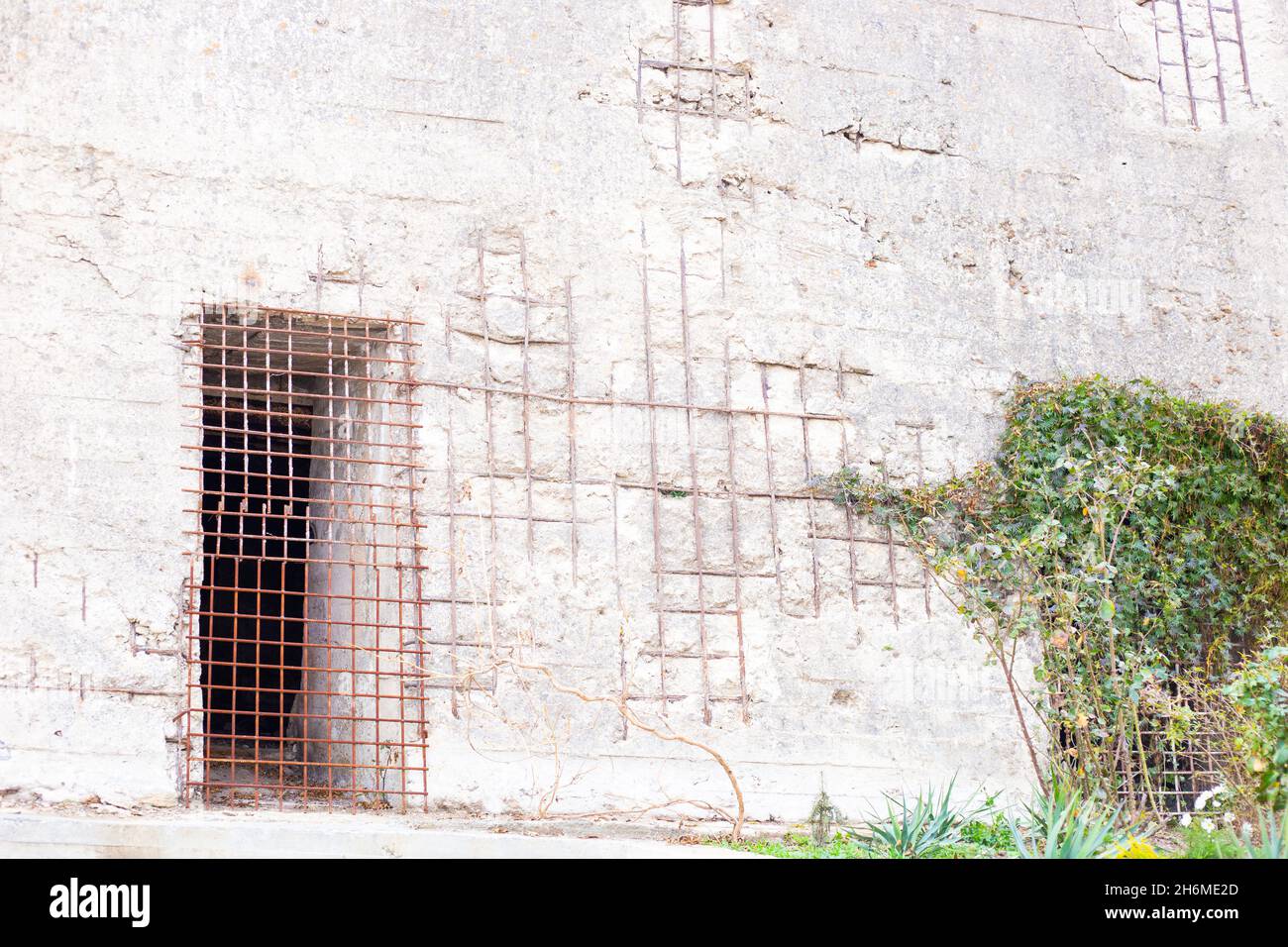 An iron grate at the entrance to an old crumbling building ...