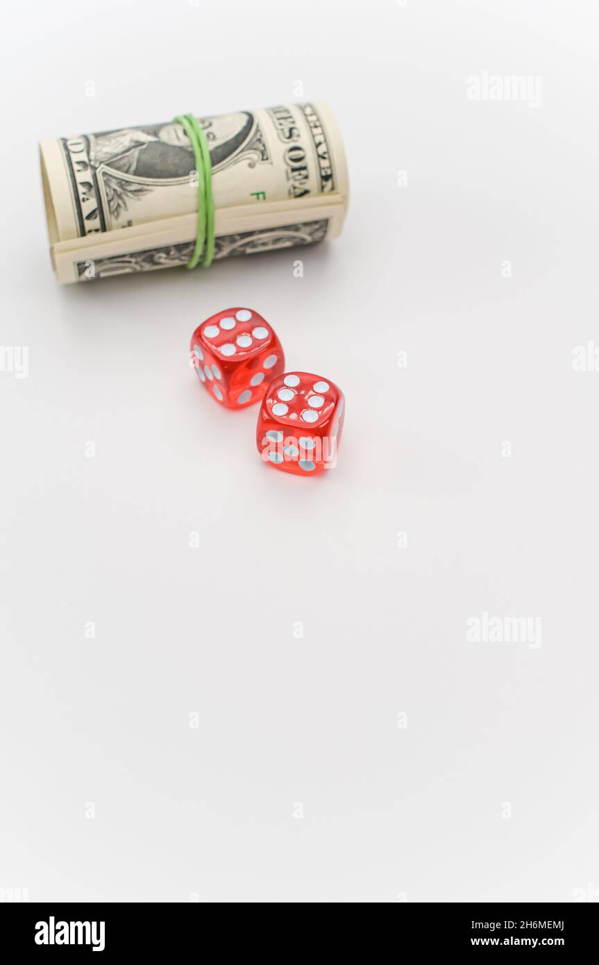 red dice and isolated US dollar banknotes roll on a white background ...