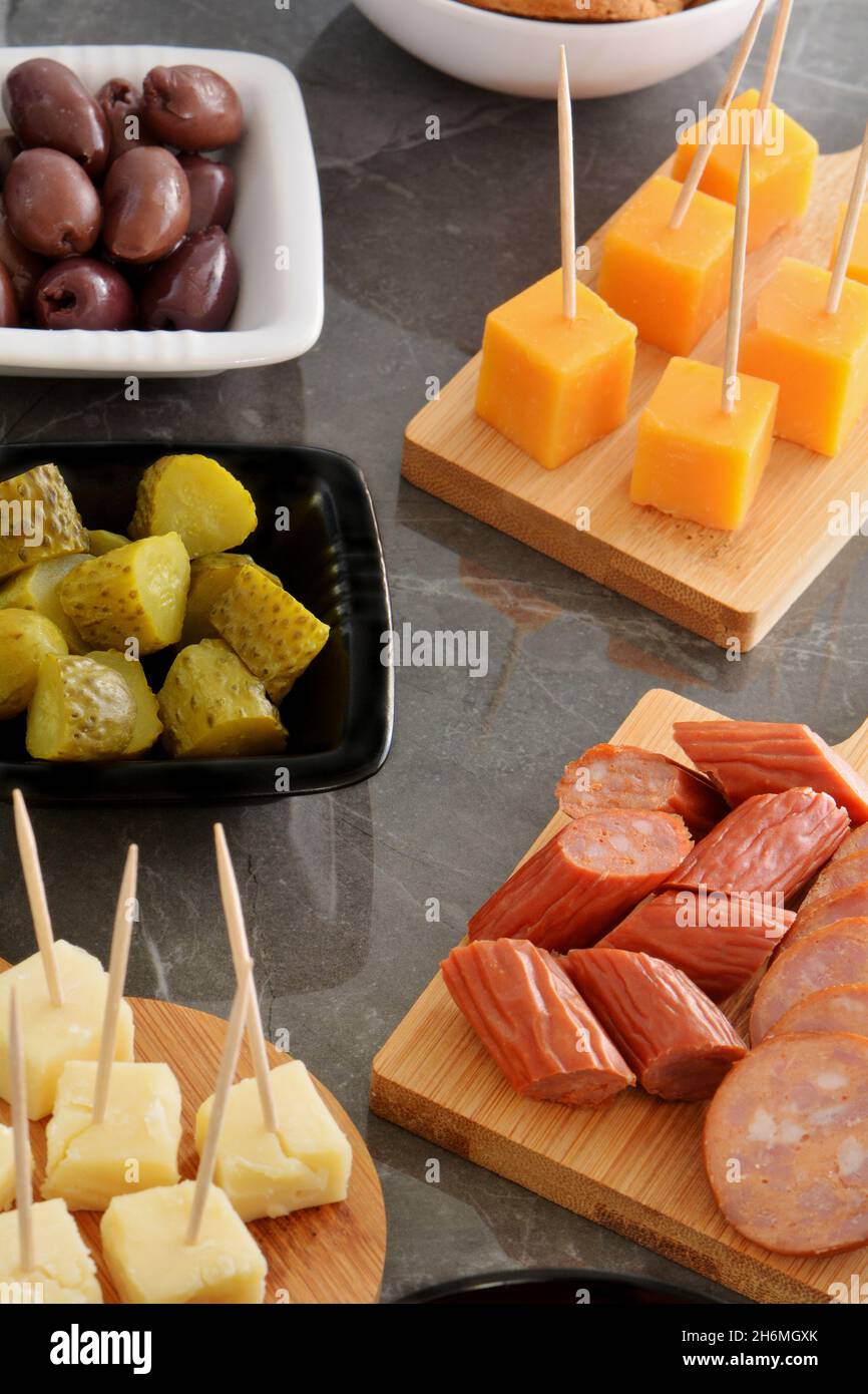 Tasty array of meats, cheeses and condiments on a dark marble ...