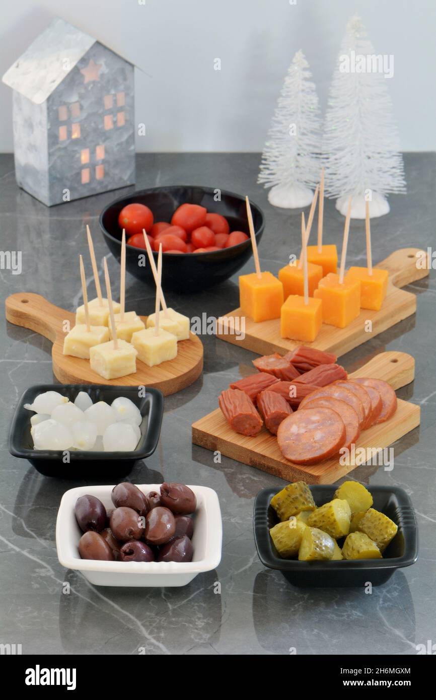 Tasty array of meats, cheeses and condiments on a dark marble ...