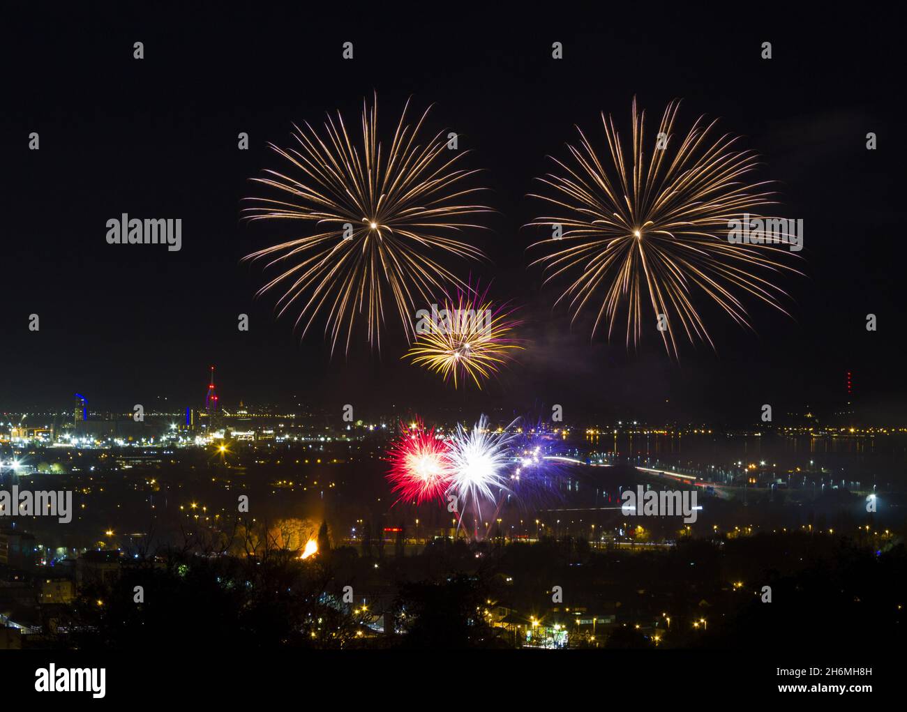 Colorful fireworks above a town during a party at night Stock Photo - Alamy