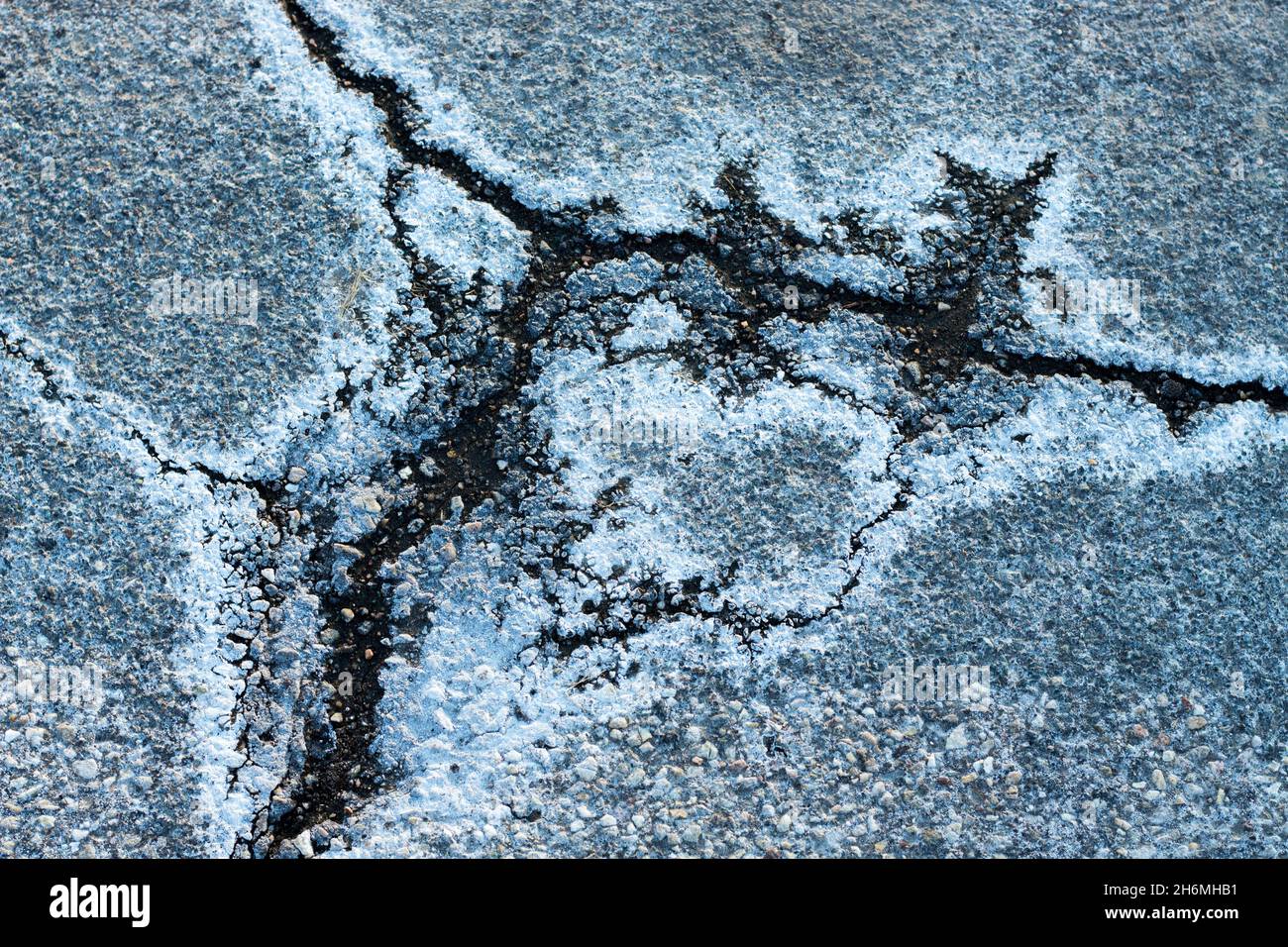 Crack in asphalt during winter with remains of road salt Stock Photo ...