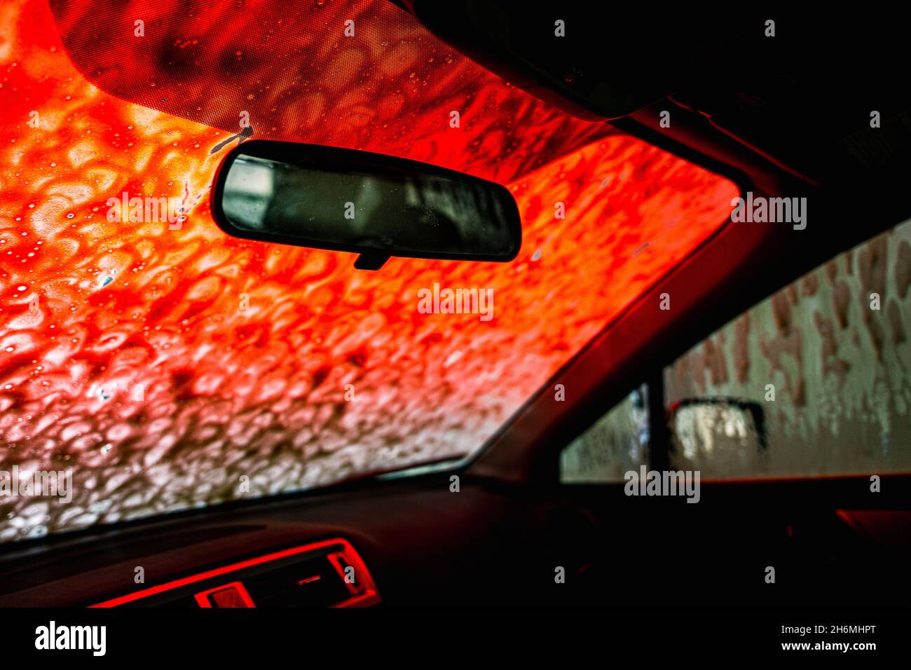 View of the car interior in the car wash with the front windshield and ...