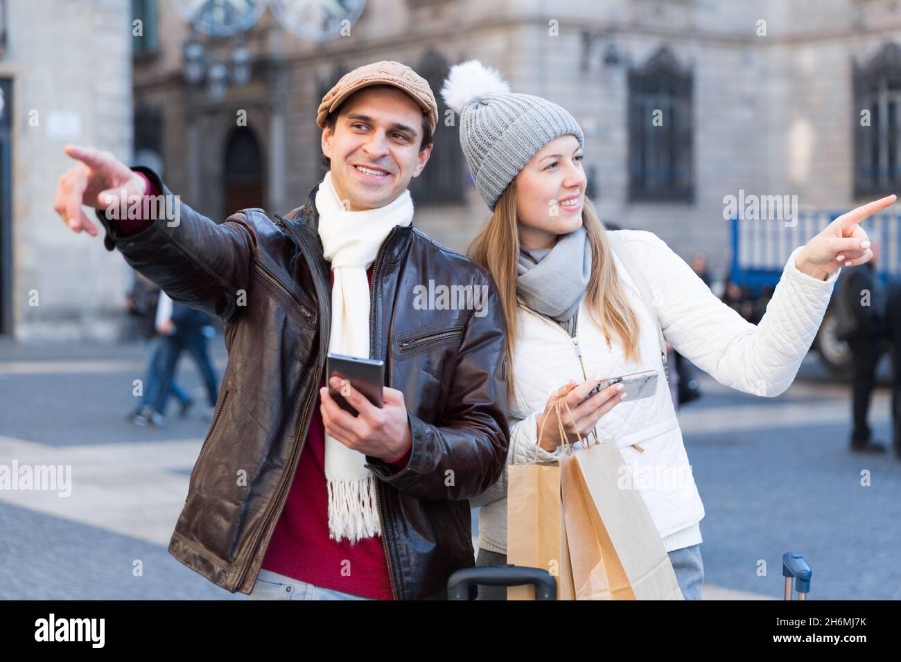 tourists in hats and scarfs pointing finger Stock Photo - Alamy