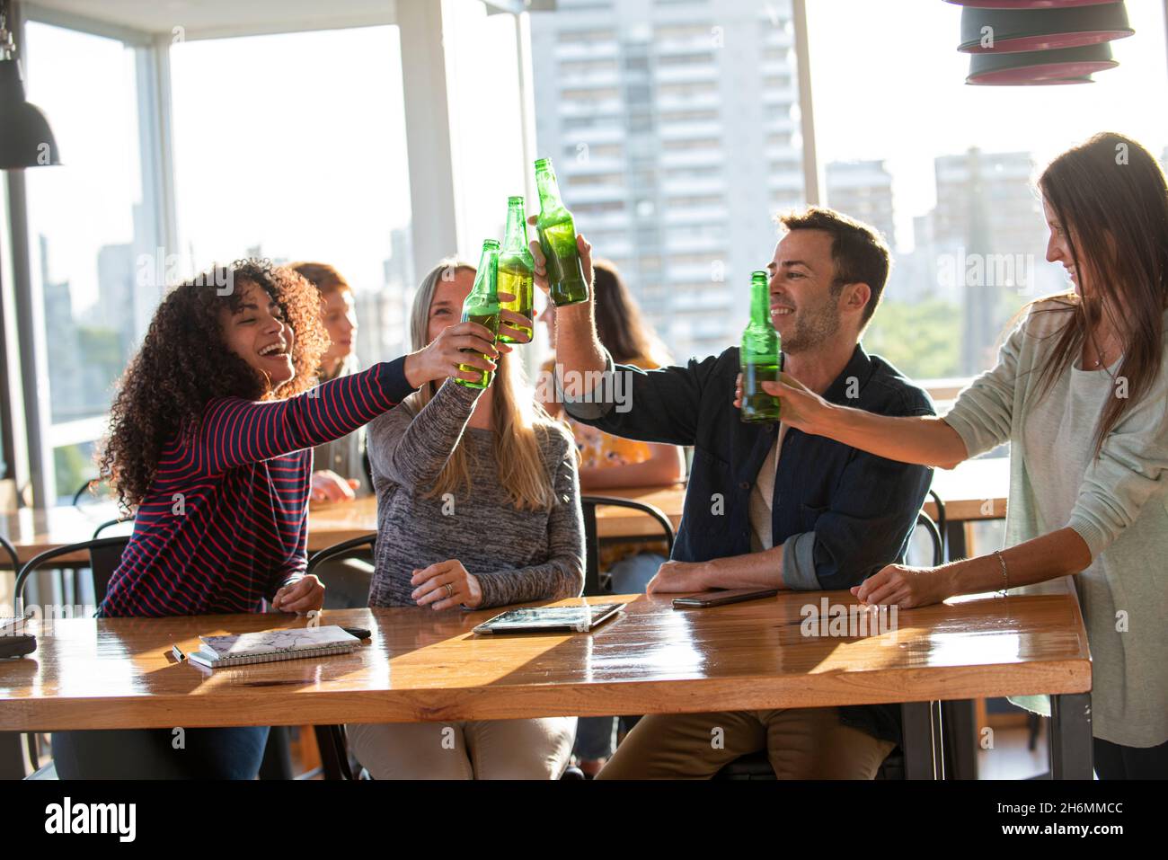 Smiling business people toasting bottles in office Stock Photo - Alamy