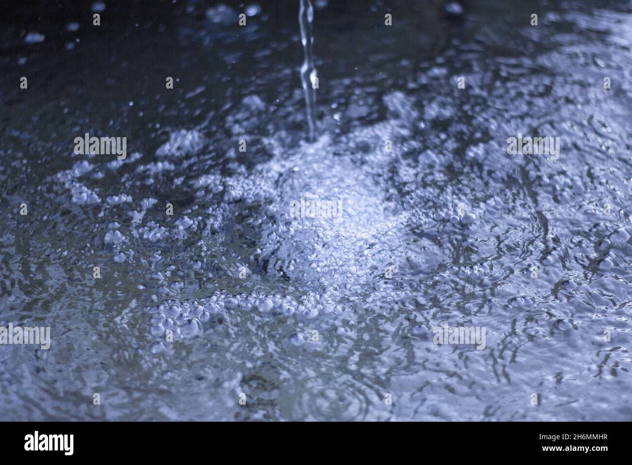 Closeup of water flowing into the water puddle Stock Photo - Alamy