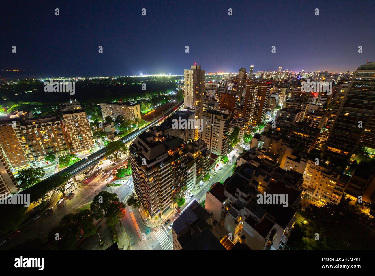 Aerial view of elevated railway bridge passing through city at night ...