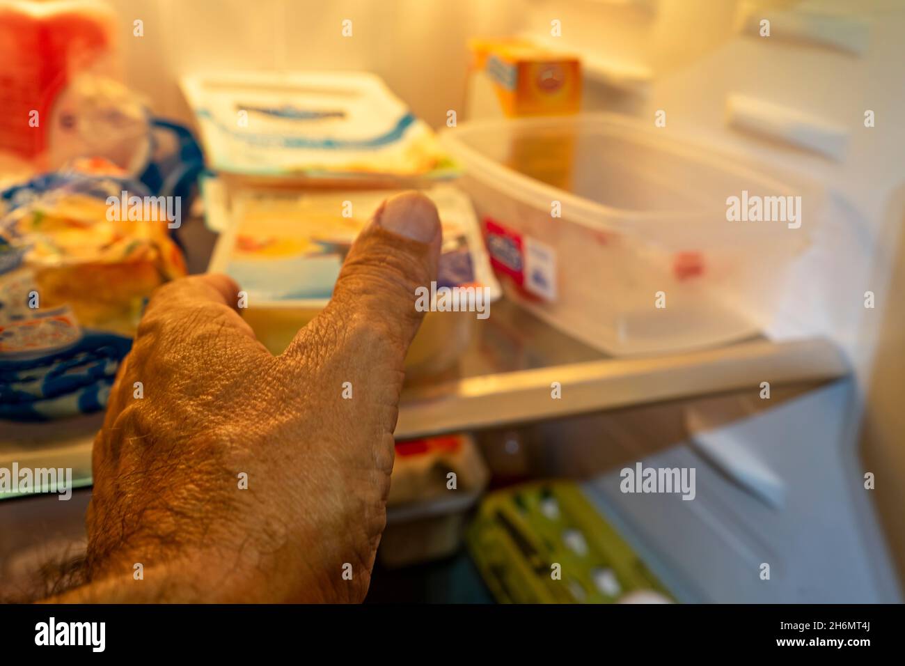 Hand of a man looking for food in the refrigerator, anxiety, and ...