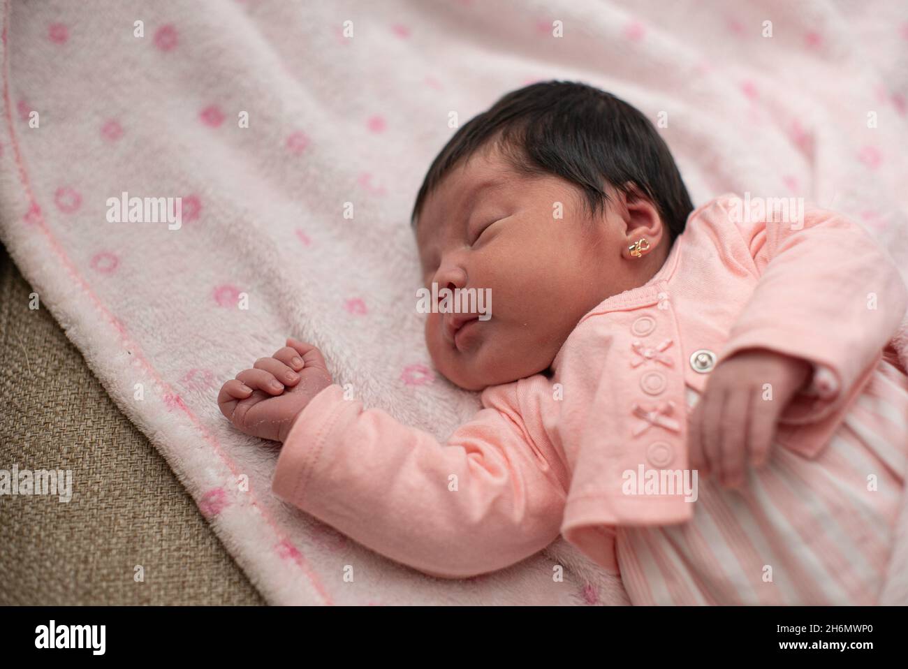 Cute Hispanic baby girl sleeping on a white and pink blanket Stock ...