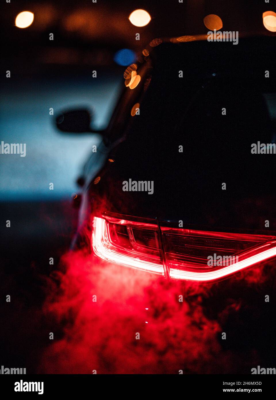 Vertical shot of the smoke coming off the car in the dark street at ...