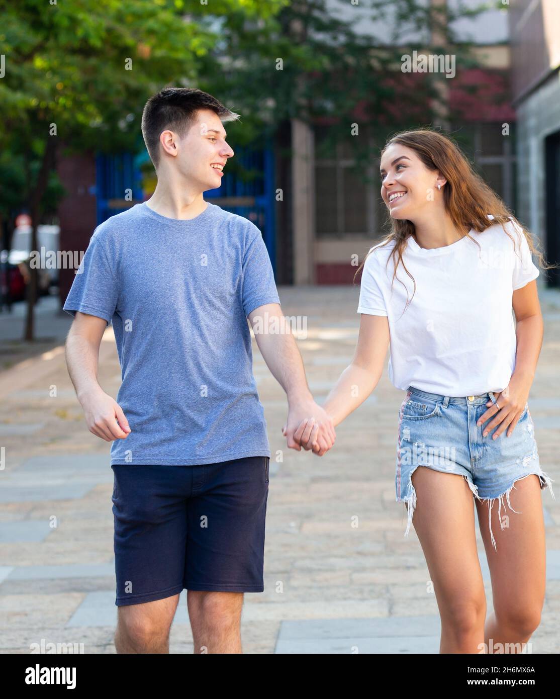 A couple of teenagers is walking hand in hand Stock Photo - Alamy