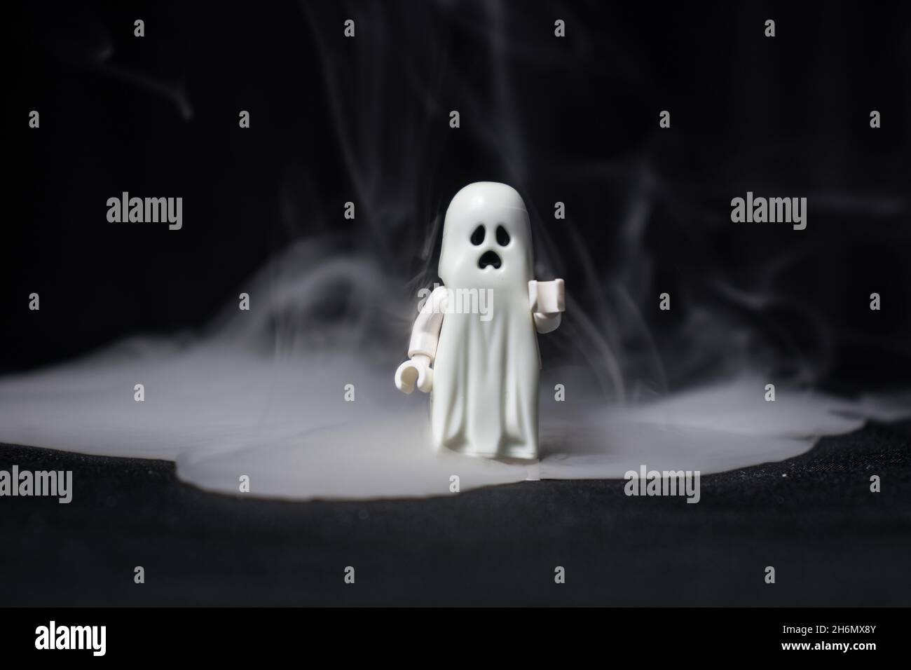 Ghost toy with smoke behind on a black background Stock Photo - Alamy