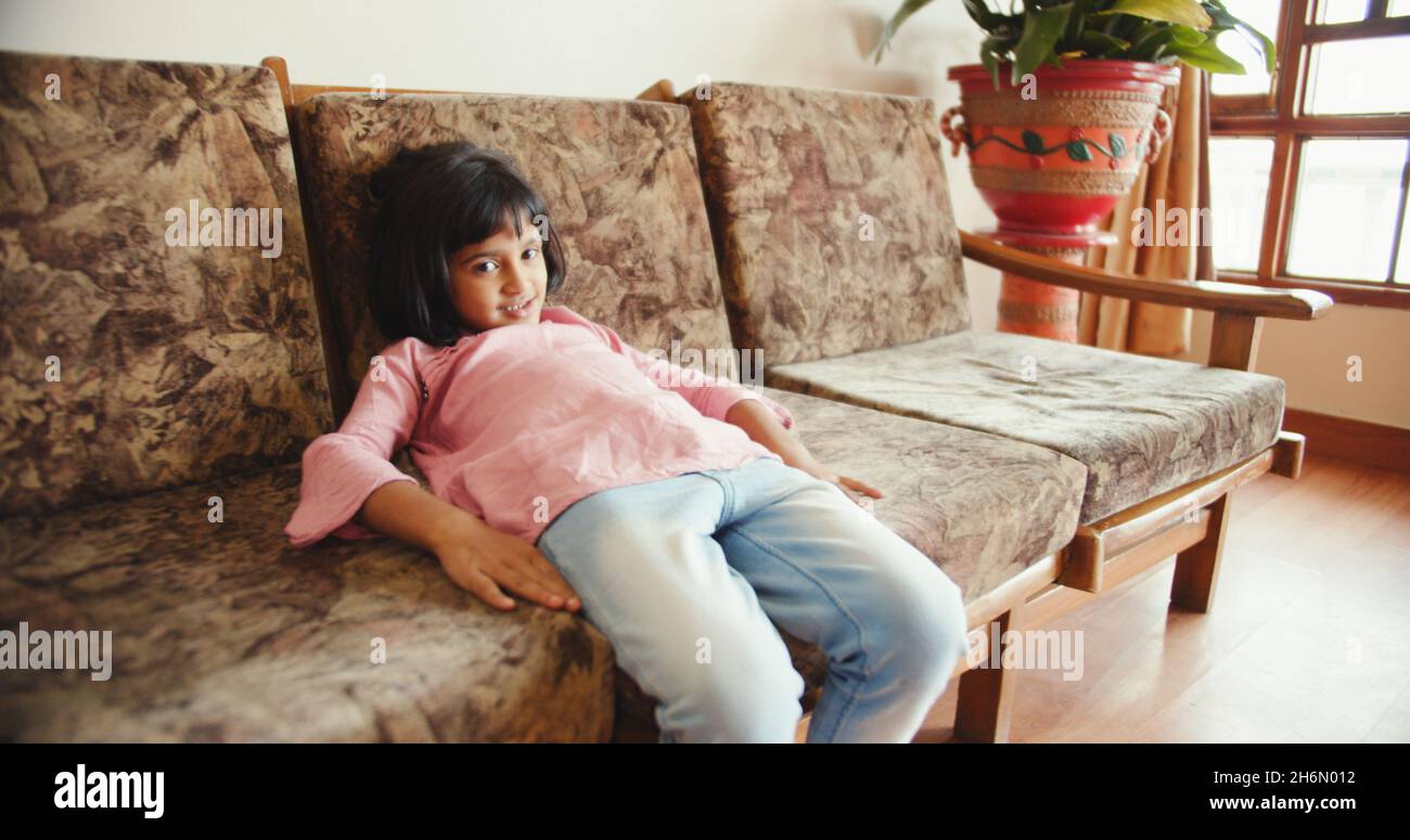 Indian kid sitting on a sofa Stock Photo - Alamy