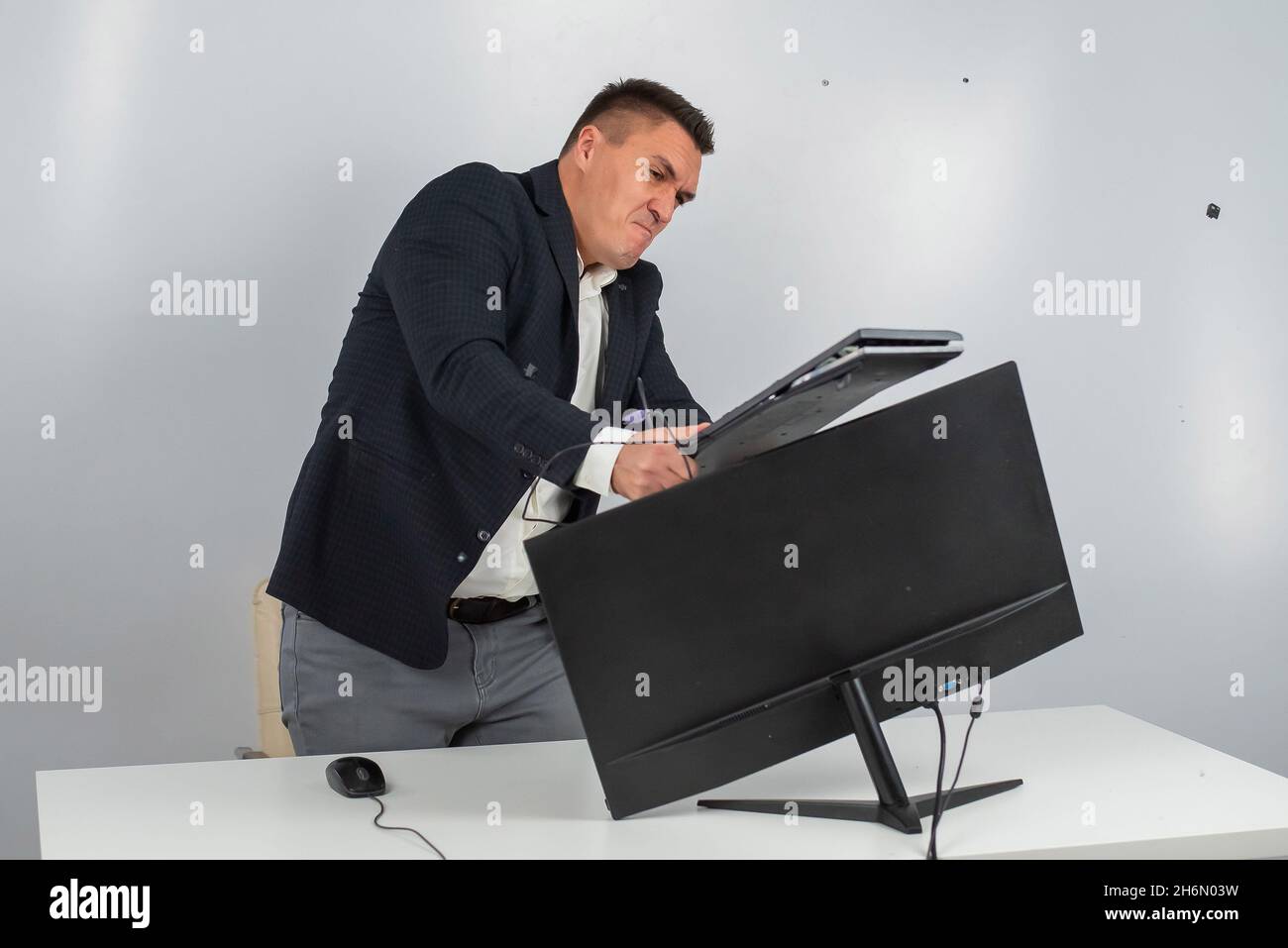 Caucasian man in a suit gets angry and smashes the keyboard on the ...