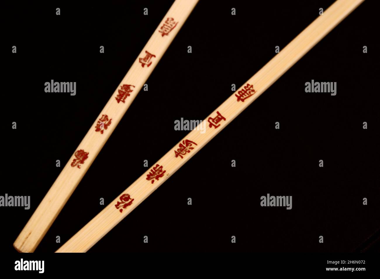 Closeup of wooden Chinese sticks for eating in the black background ...