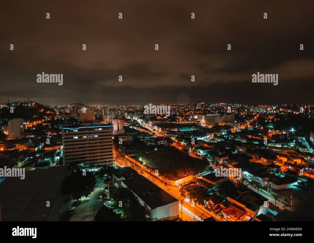 Night view of a city with orange street lights and dark clouds in the ...