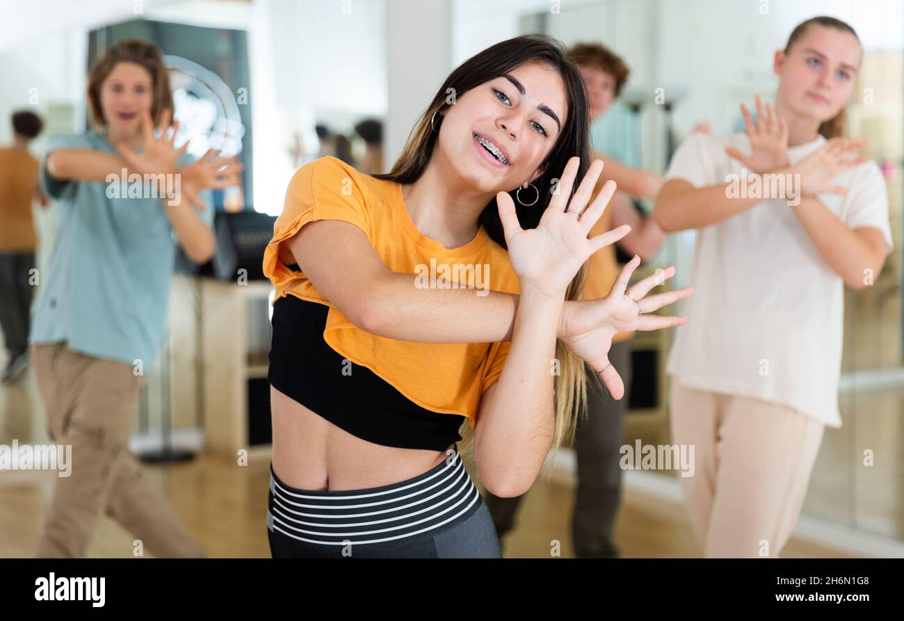 Cheerful emotional teen girl training dance movements in choreography ...