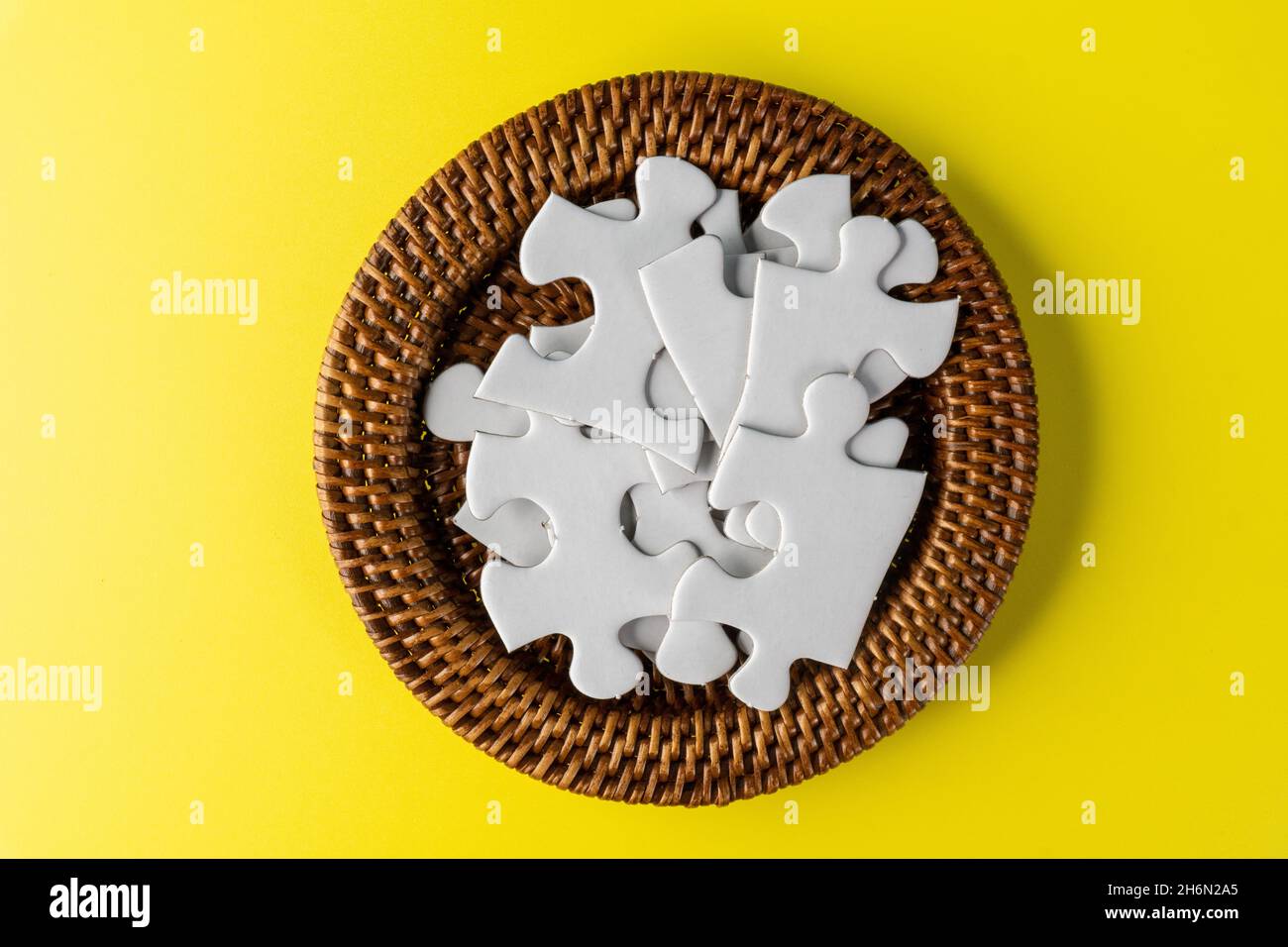 White jigsaw puzzle in container under yellow background Stock Photo ...