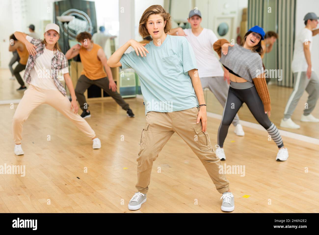 Teen b-boy dancing with group of friends in dance studio Stock Photo ...
