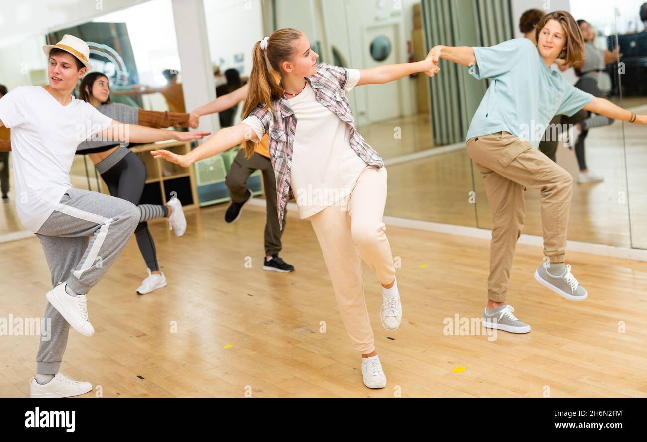 Sporty cheerful teenagers learning to dance jive in pairs Stock Photo ...
