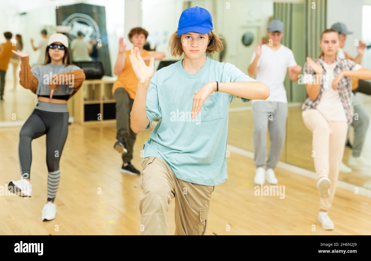 Teen b-boy dancing with group of friends in dance studio Stock Photo ...