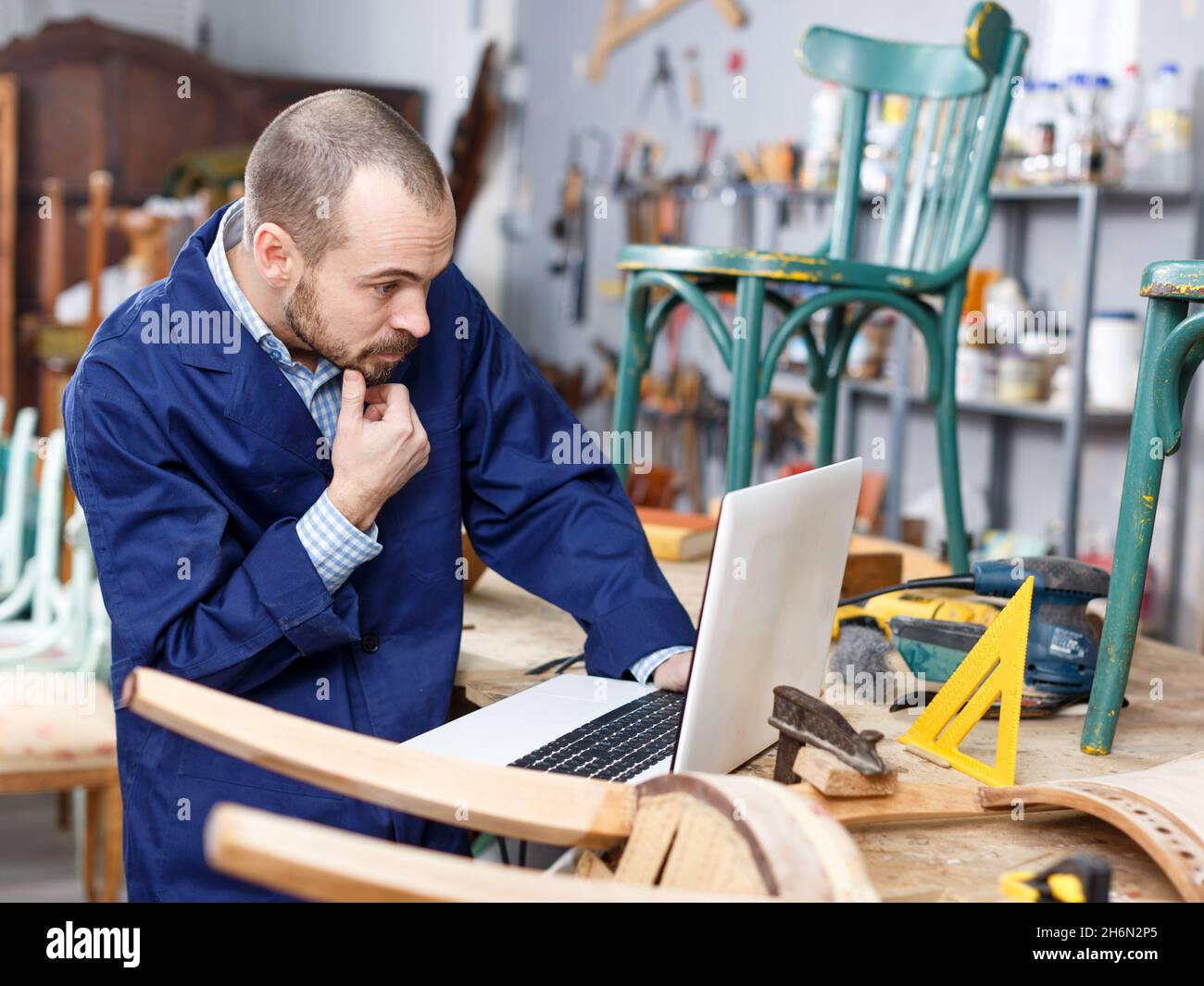 Restorer using laptop in process of renovation Stock Photo - Alamy