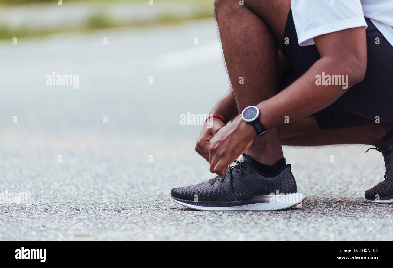 Close up Asian sport runner black man wear watch sitting he trying ...
