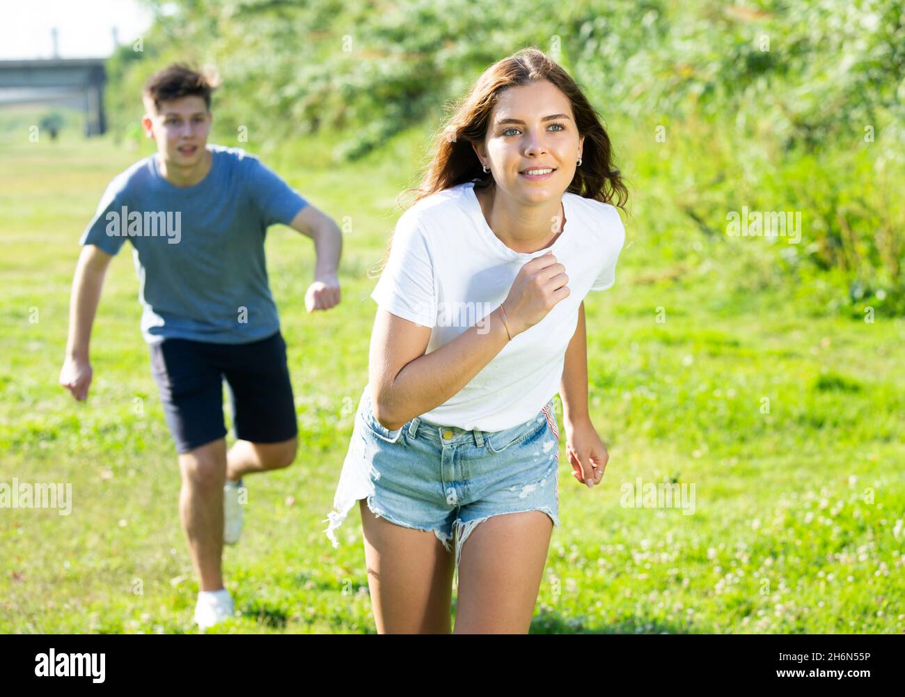 Cheerful teenagers are jogging together in park and having fun Stock ...
