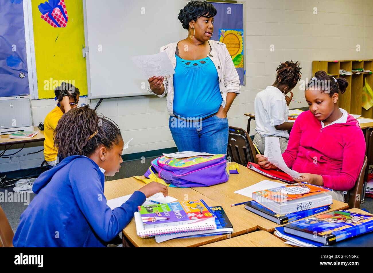An Elementary School Teacher Goes Over A Lesson Plan With Her Students an-elementary-school-teacher-goes-over-a-lesson-plan-with-her-students