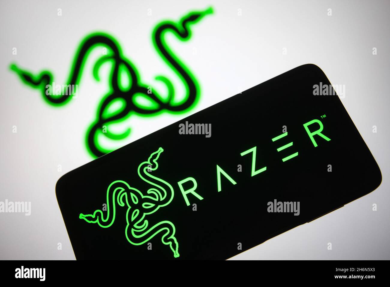 In this photo illustration, a Razer Inc. logo is seen on a smartphone screen and in the ...