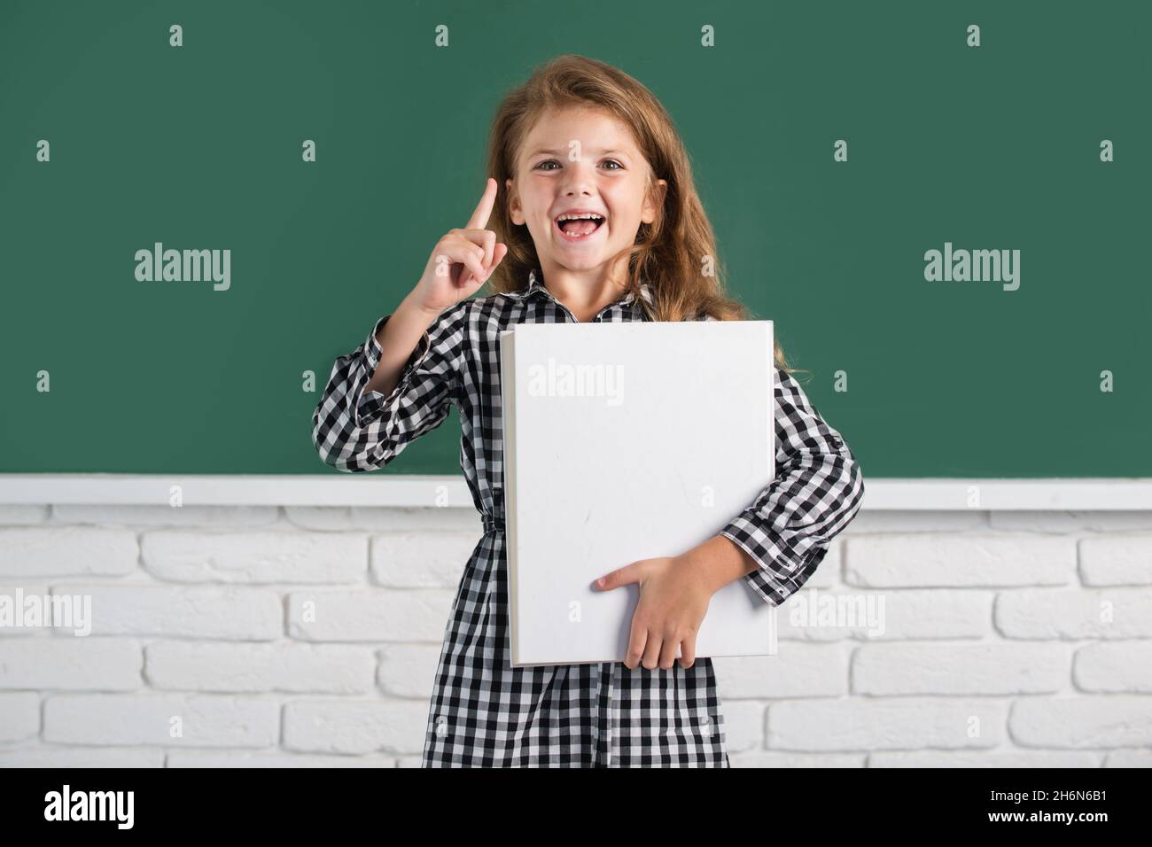 Cute child at school. Kid is learning in class on background of ...
